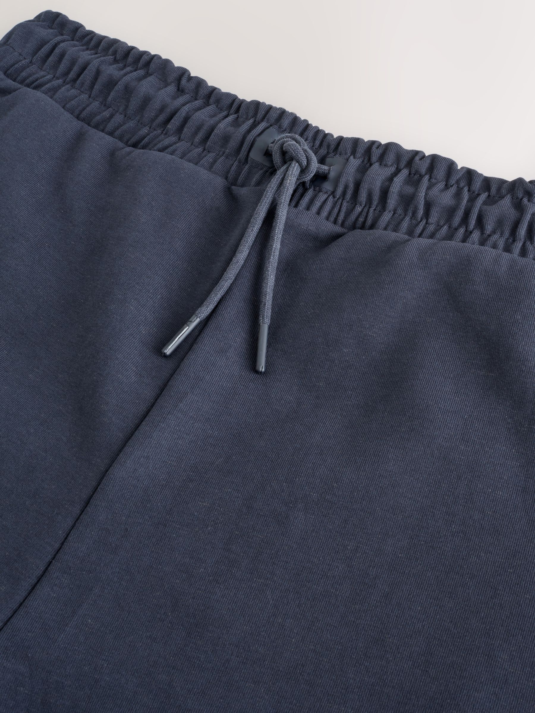 Buy Navy Blue Interlock Soft Touch Slim Fit Cuffed Joggers from the ...